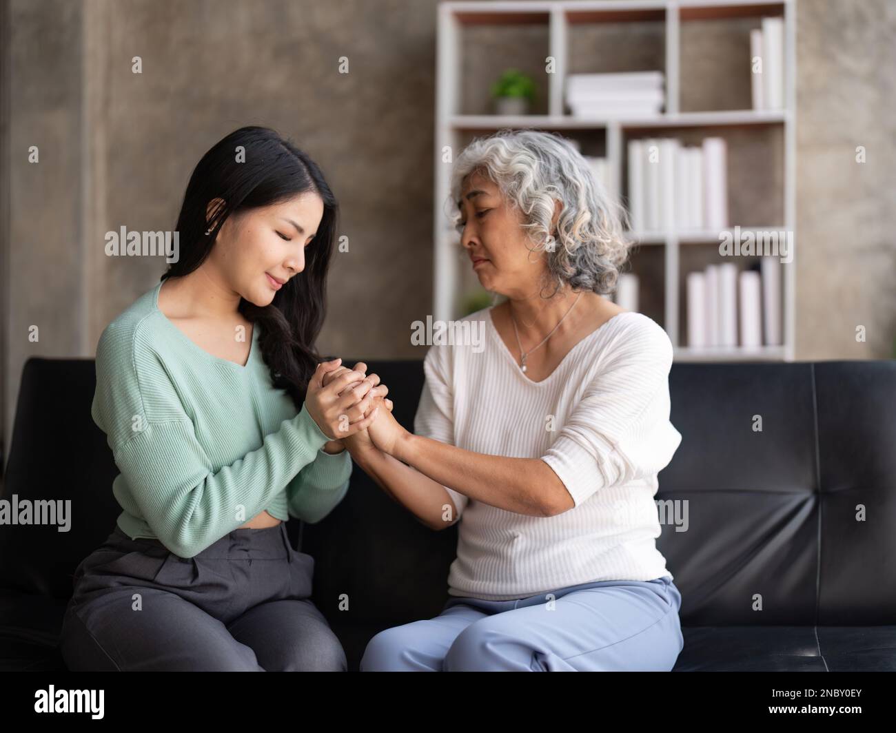 Daughter talking to sad mother holding hand comforting upset having ...