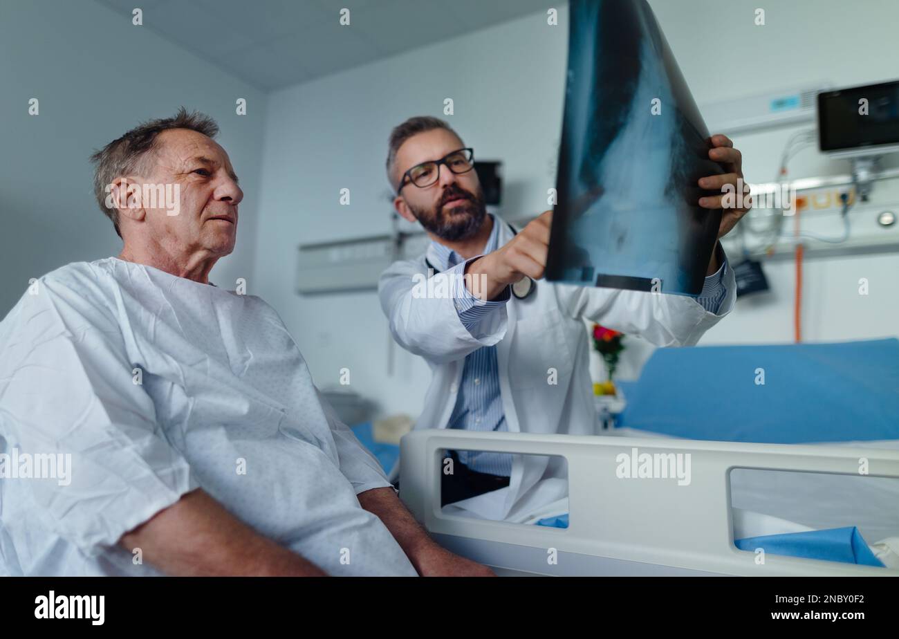 Mature doctor showing elderly patient x-ray image of lungs Stock Photo ...