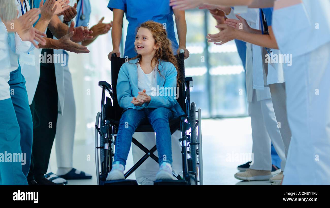 Medical staff clapping to little girl patient who recovered from ...