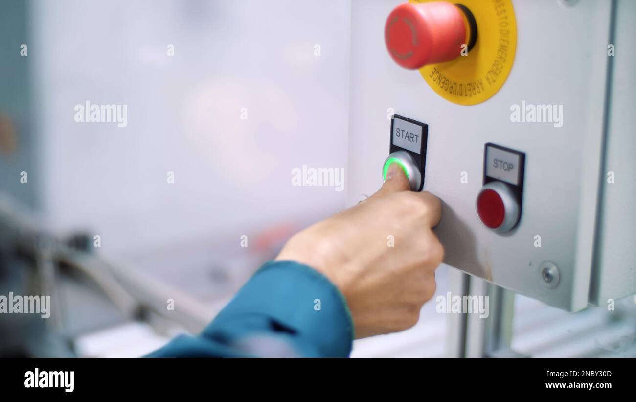 close-up, on a special shield, the hand presses the green start button ...