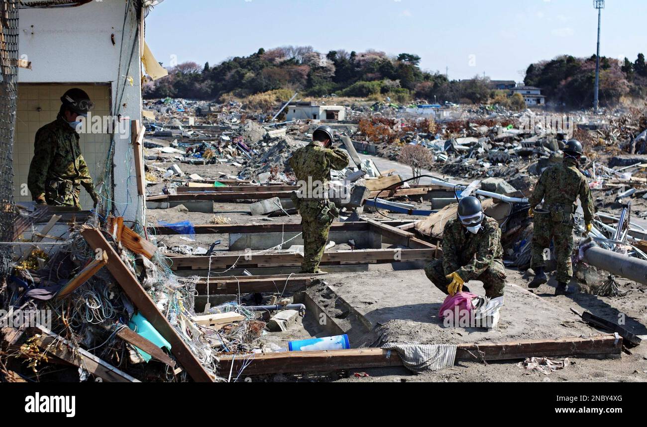 Japan Ground Self-Defense Force members sift through the rubble in the ...