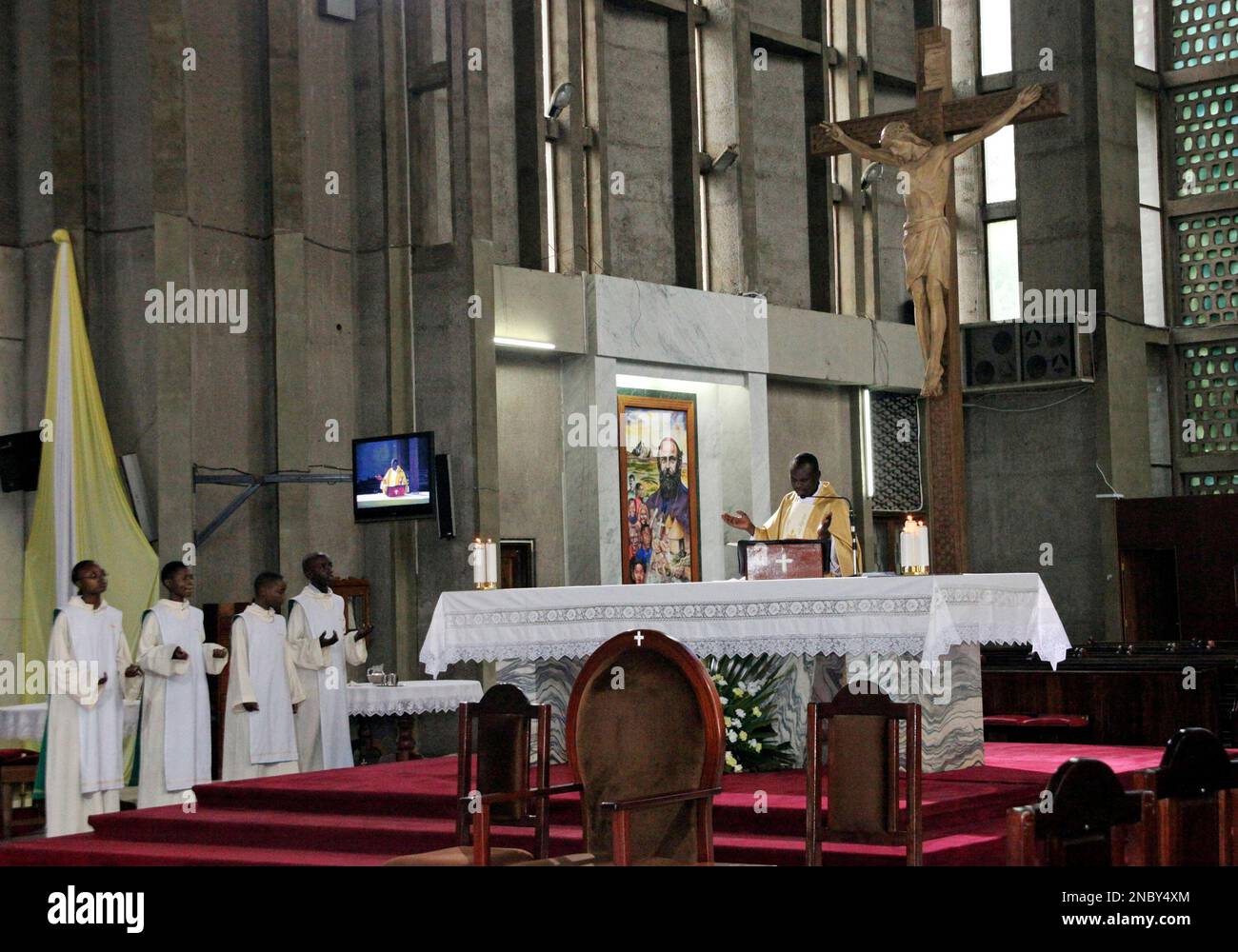 A priest leads Kenyan Christians in a morning service at Holy Family ...