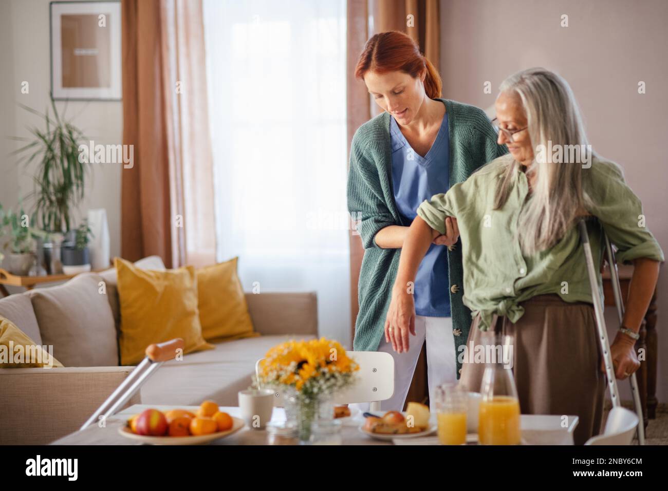 Nurse helping senior woman with walking after leg injury Stock Photo ...