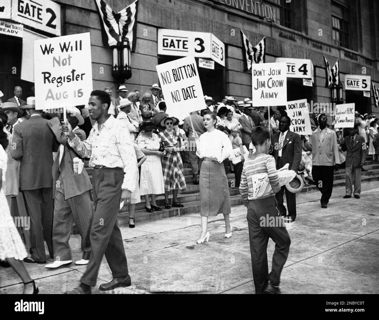 Sign-carrying marchers parade at the main entrance to convention hall ...