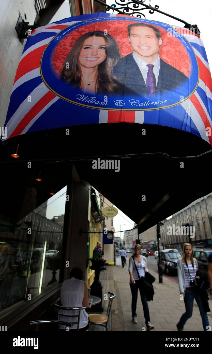 People walk by a cafe in London flying the Union flag with a central ...