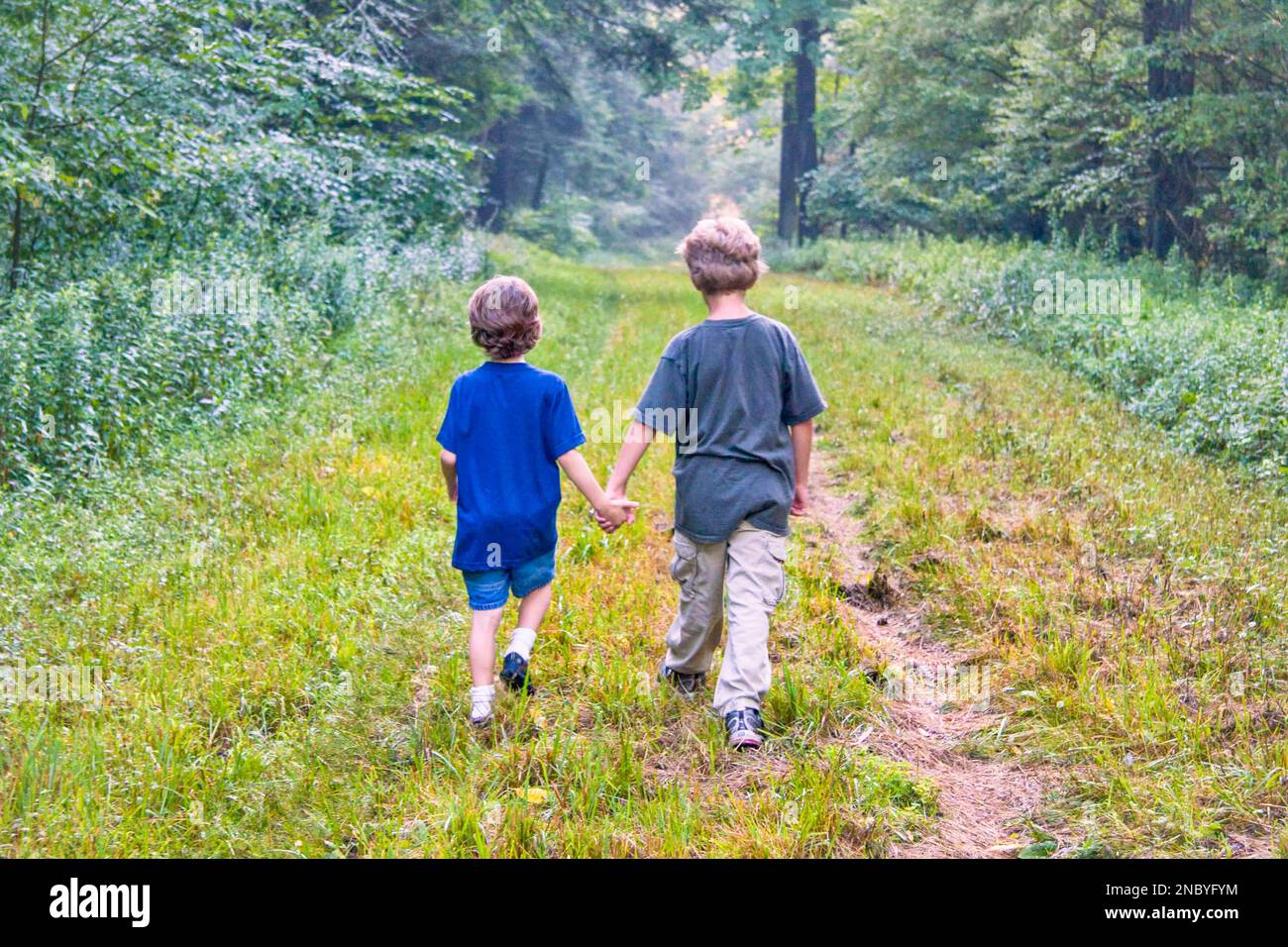 2 Two young Boy Cousins walk through the forest on a late summer ...