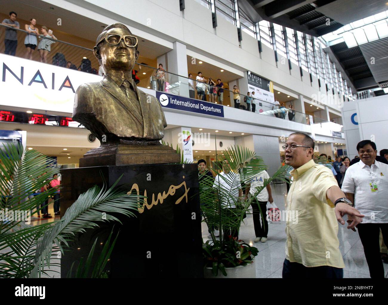 Philippine President Benigno Aquino III gestures beside the bust of his ...