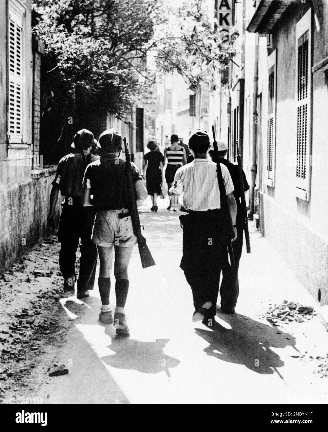 Rifles slung over their backs, four citizen soldiers’ of France leave ...