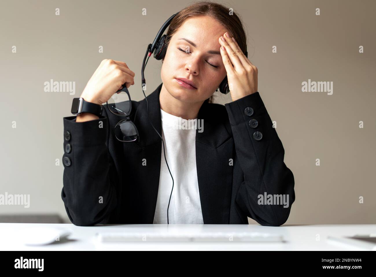 Feeling unwell at work.Tired operator of call center with closed eyes ...