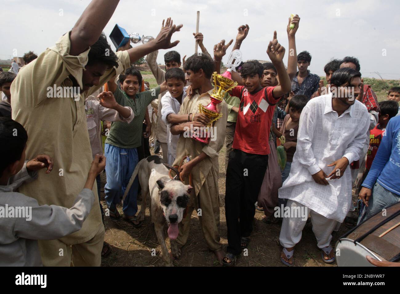 People celebrate a victory with their dog in a dog fight in Lahore ...