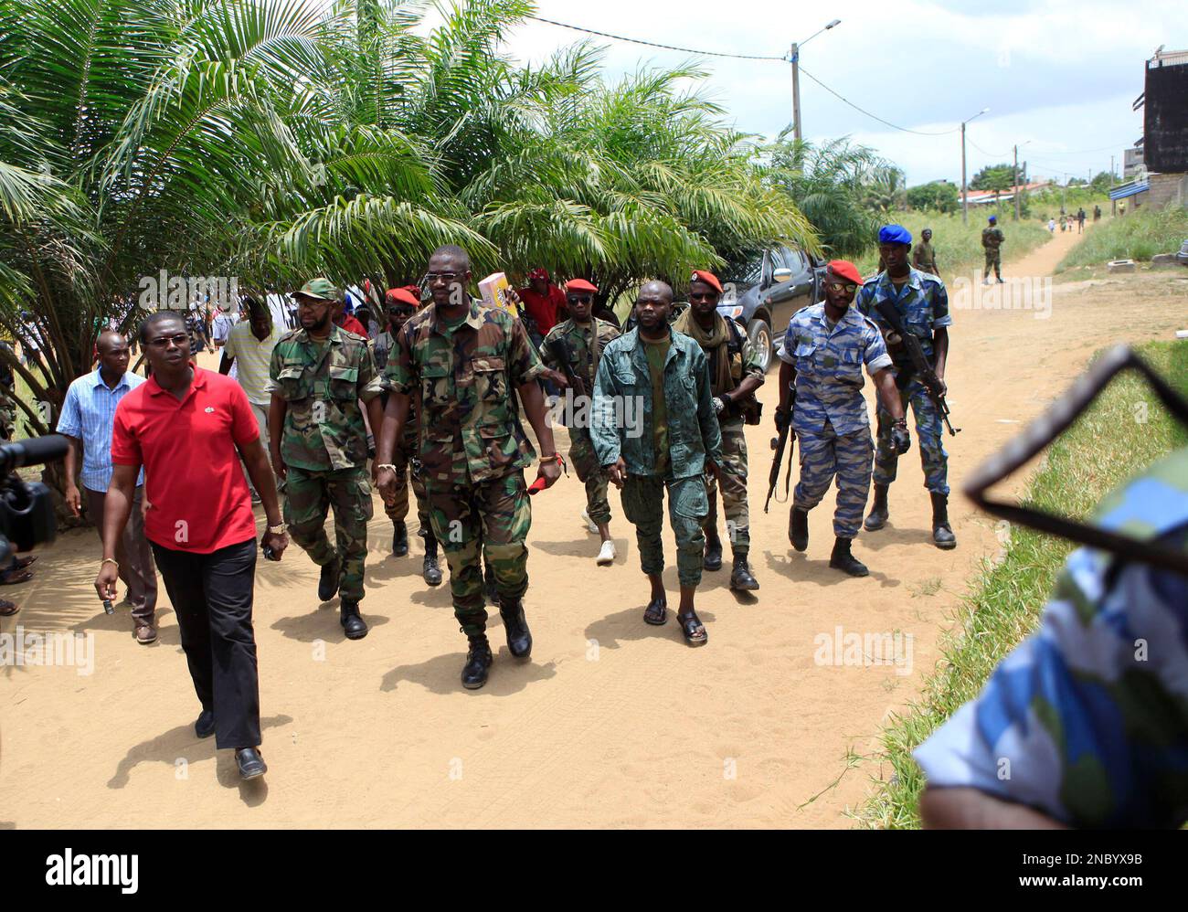 Gen. Ibrahim Coulibaly, known as IB, center left, walks with troops and ...