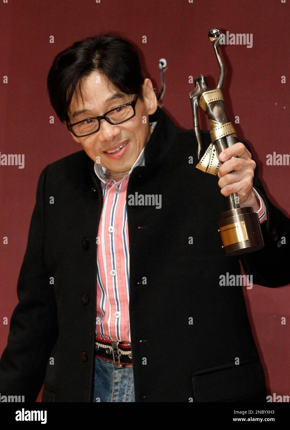 Hong Kong actor Teddy Robin displays his trophy after winning the Best ...