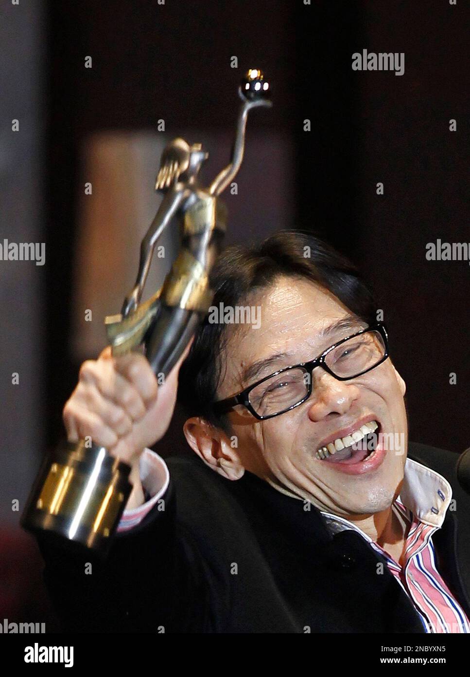 Hong Kong actor Teddy Robin celebrates with the trophy after winning ...