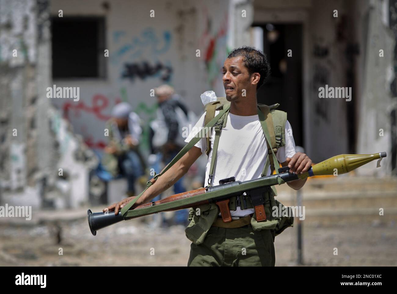 A Libyan rebel fighter armed with a rocket propelled grenade launcher ...