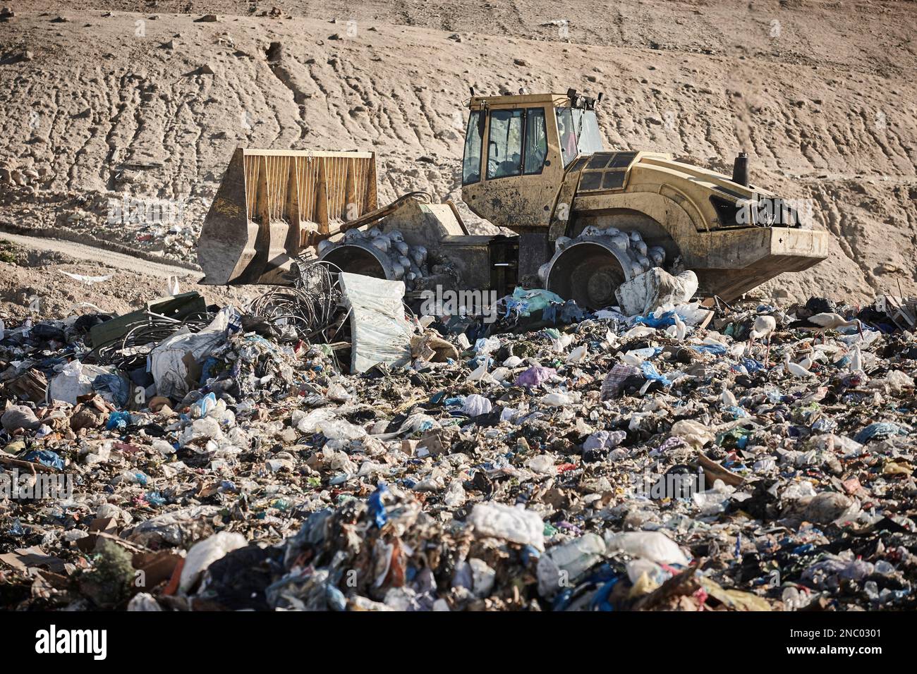 Heavy machinery shredding garbage in an open air landfill. Waste Stock ...