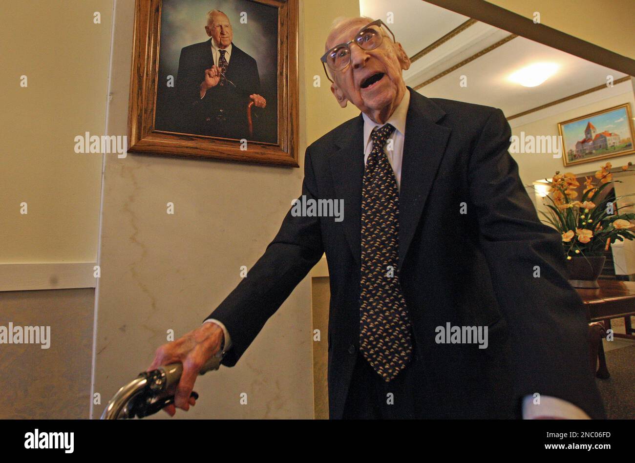 114 year old Walter Breuning stands under a portrait of himself in the ...