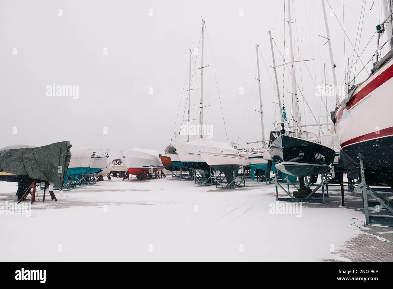 Sailboats in winter-storage on land in a snow storm Stock Photo - Alamy