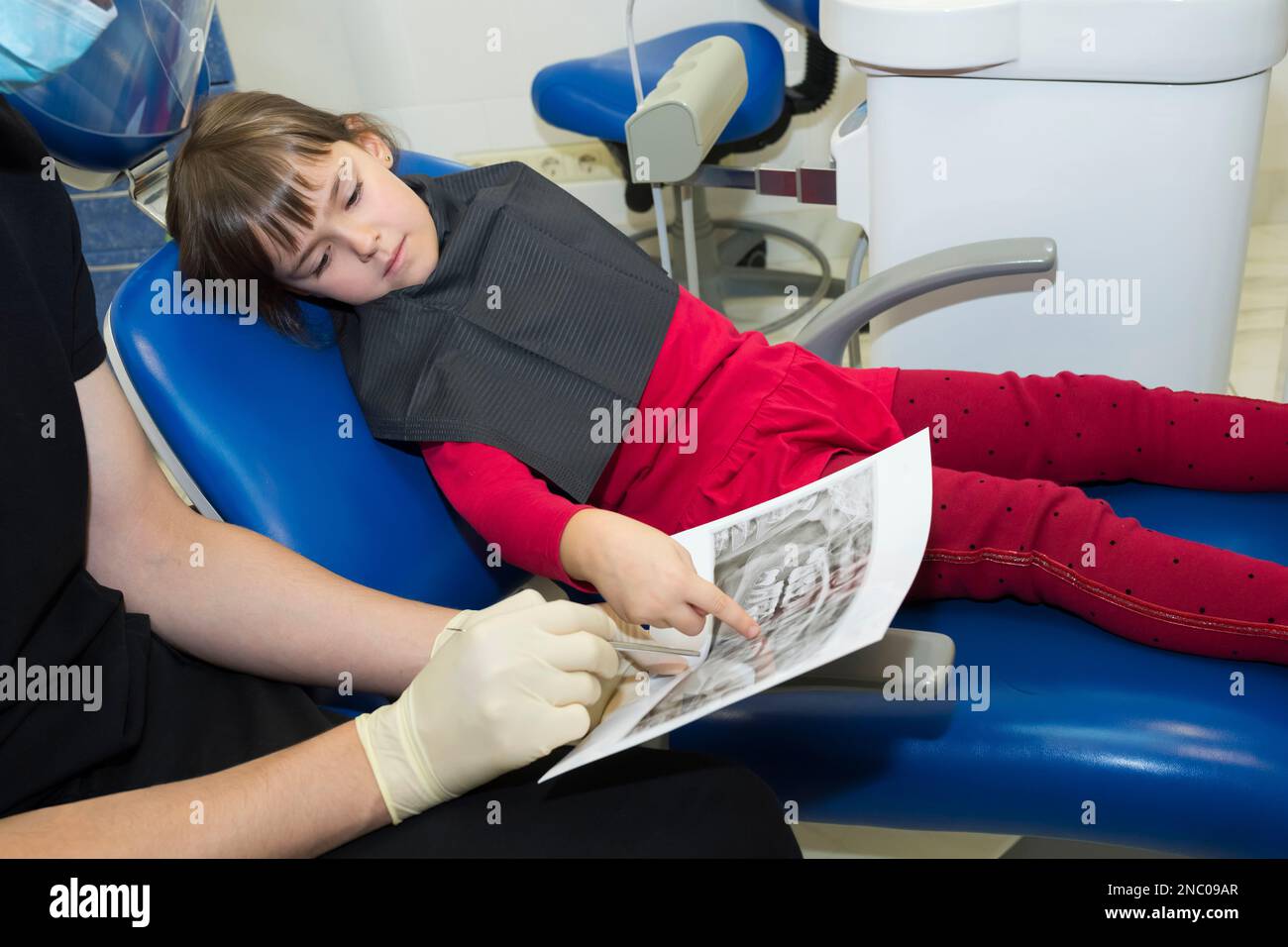A dentist showing dental X-rays (radiographs) to a patient, a kid Stock ...