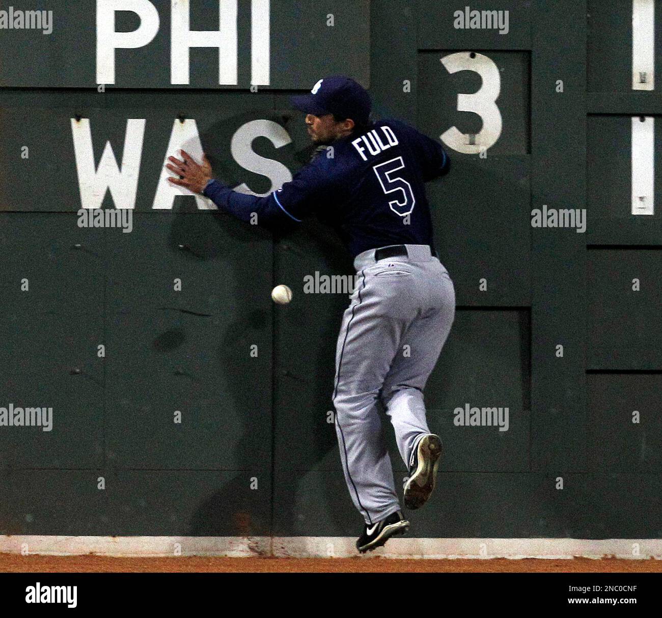 Tampa Bay Rays left fielder Sam Fuld hits the wall as he tries to field ...