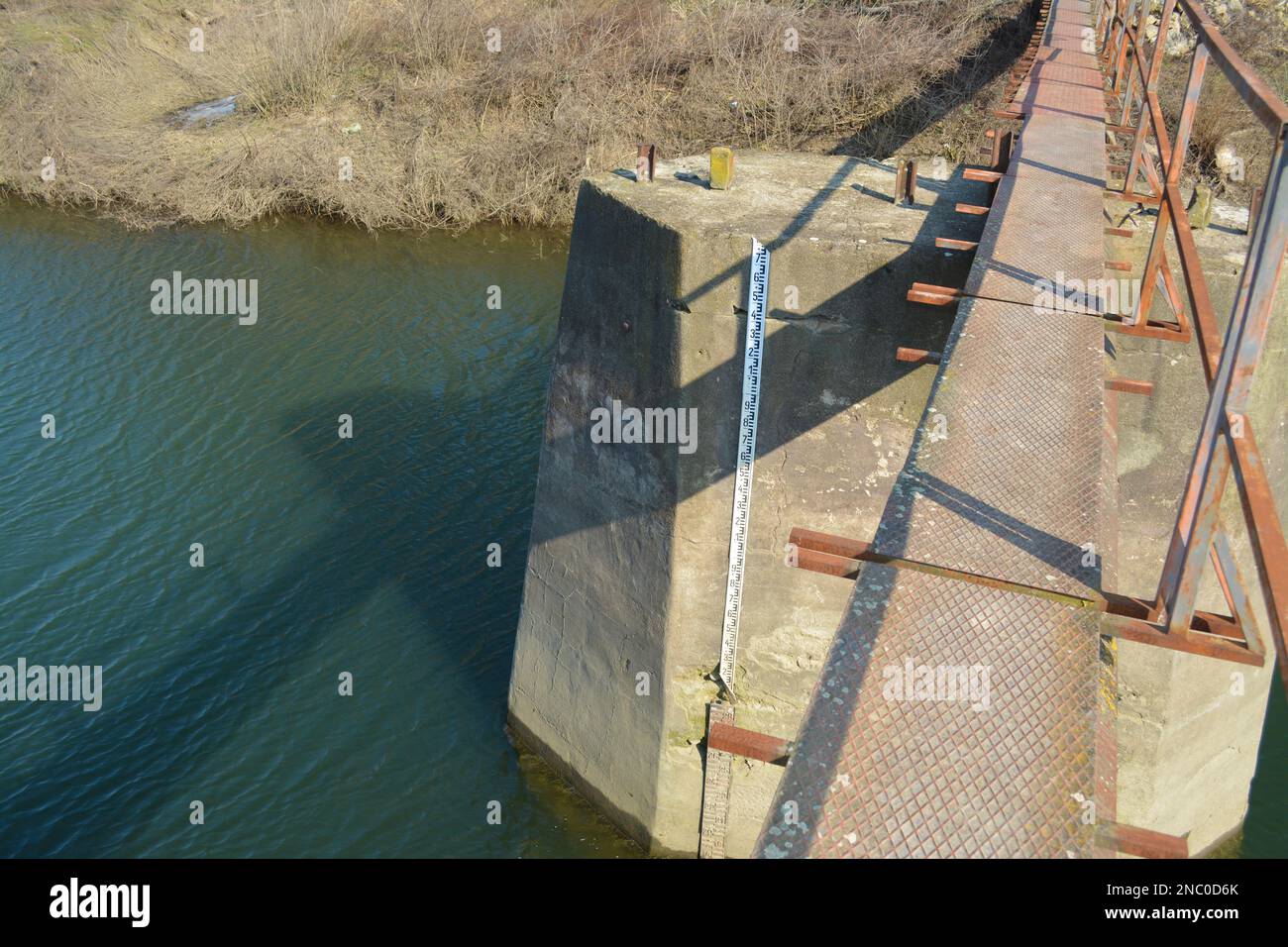 Water meter bar under rusted old bridge on shallow river Stock Photo ...