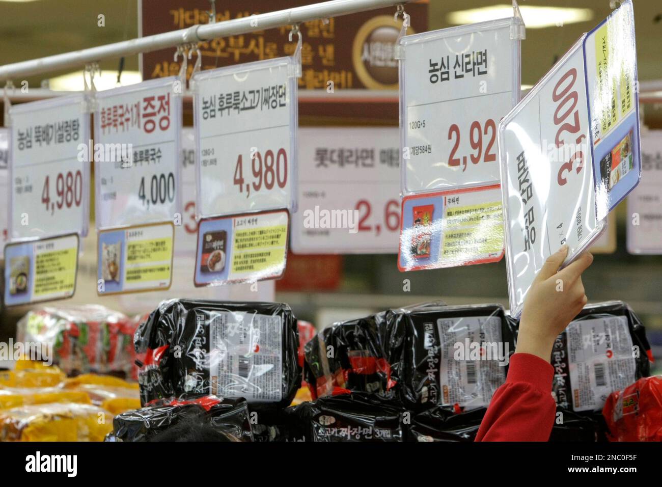 A clerk displays a price tag at a store in Seoul, South Korea, Tuesday ...