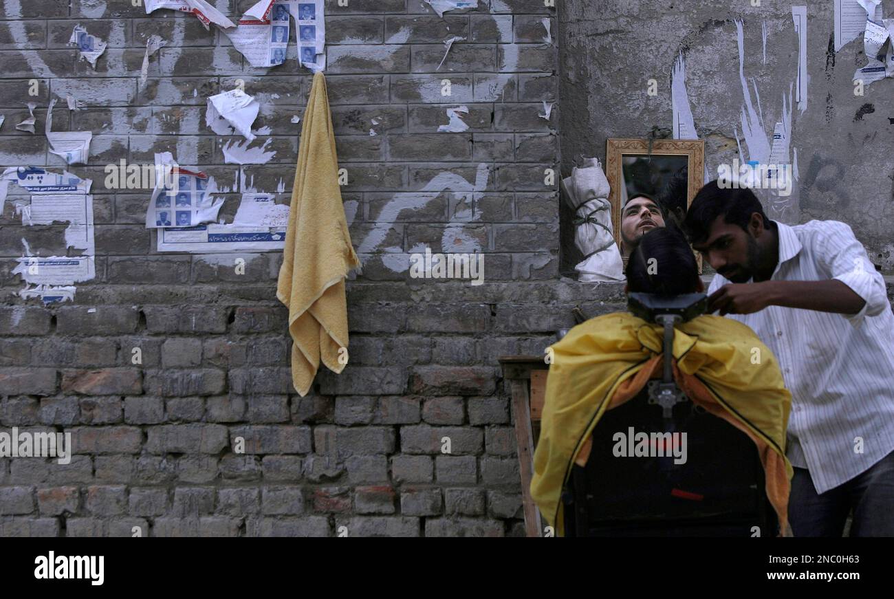 A Pakistani street barber shaves a customer's beard in a Christian ...