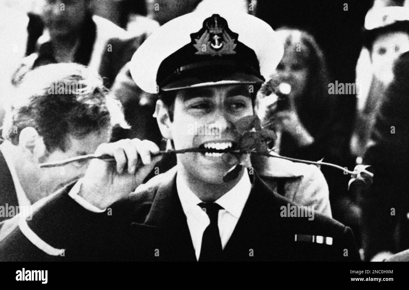 Britain’s Prince Andrew bites the stem of a red rose, after stepping ...