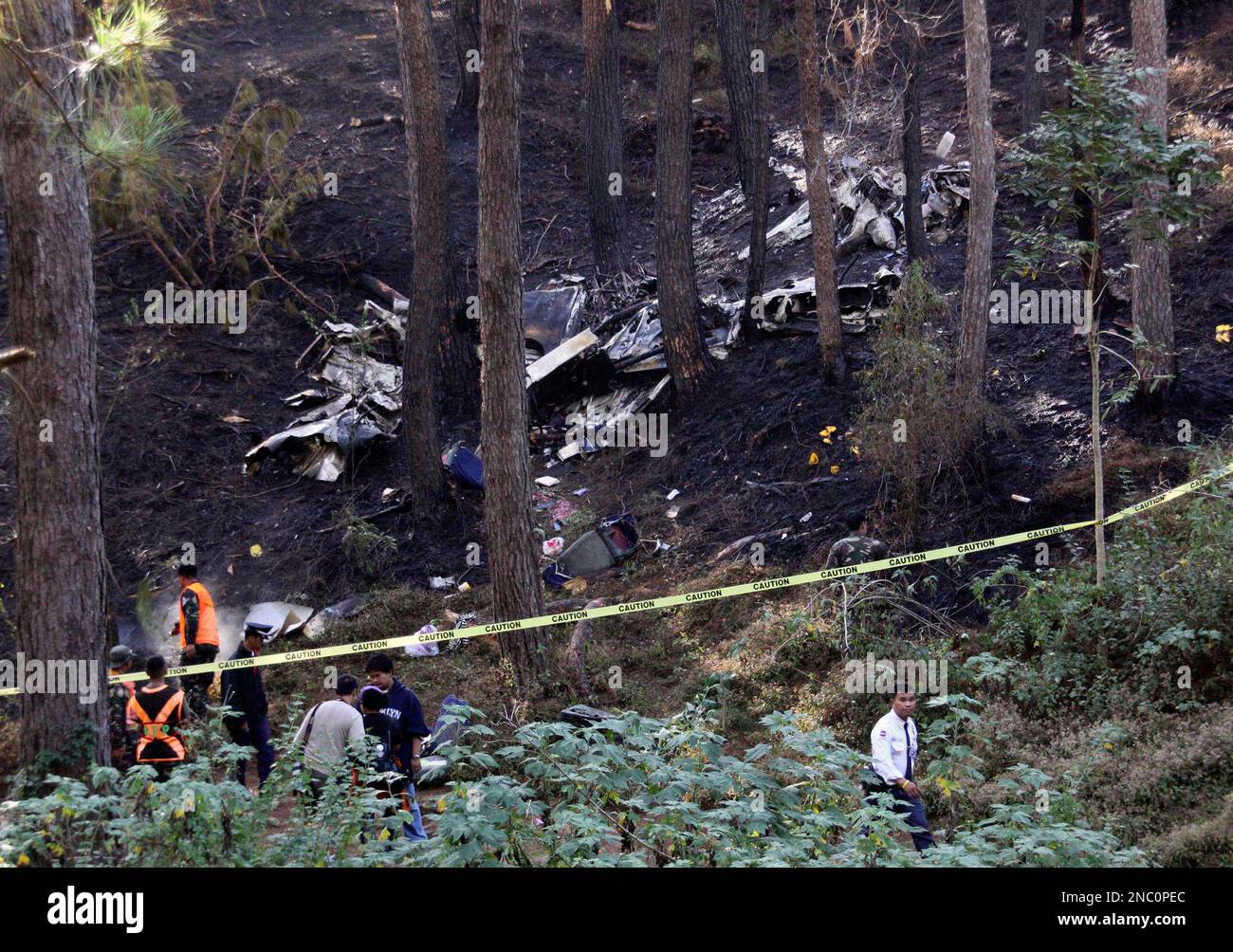 Investigators inspect the wreckage of the six-seater Piper Aztec plane ...