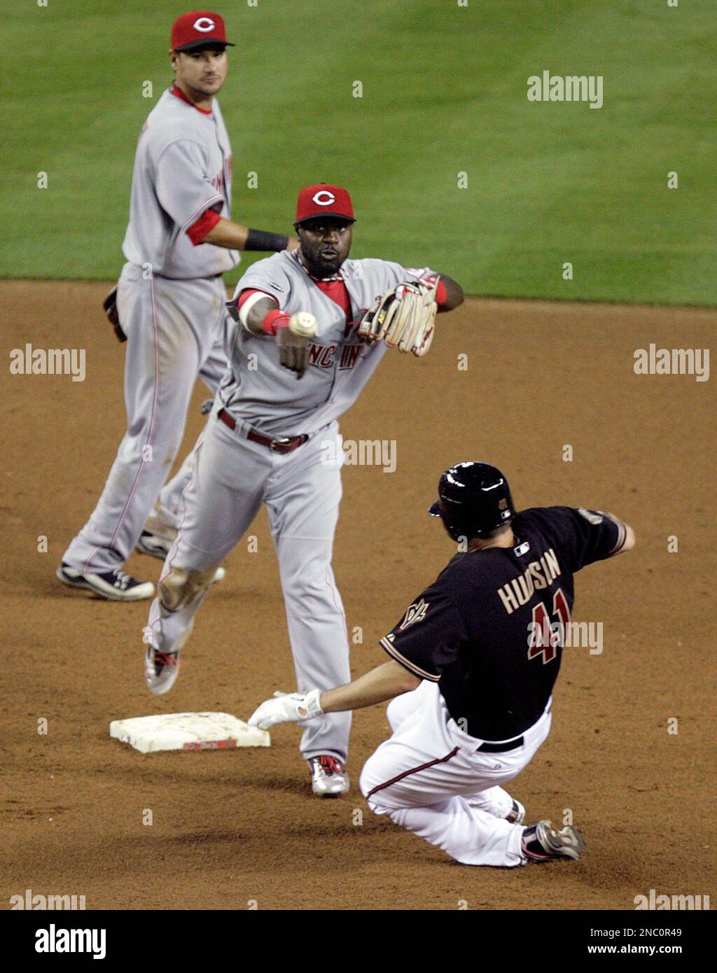 Cincinnati Reds second baseman Brandon Phillips, center, turns to throw ...