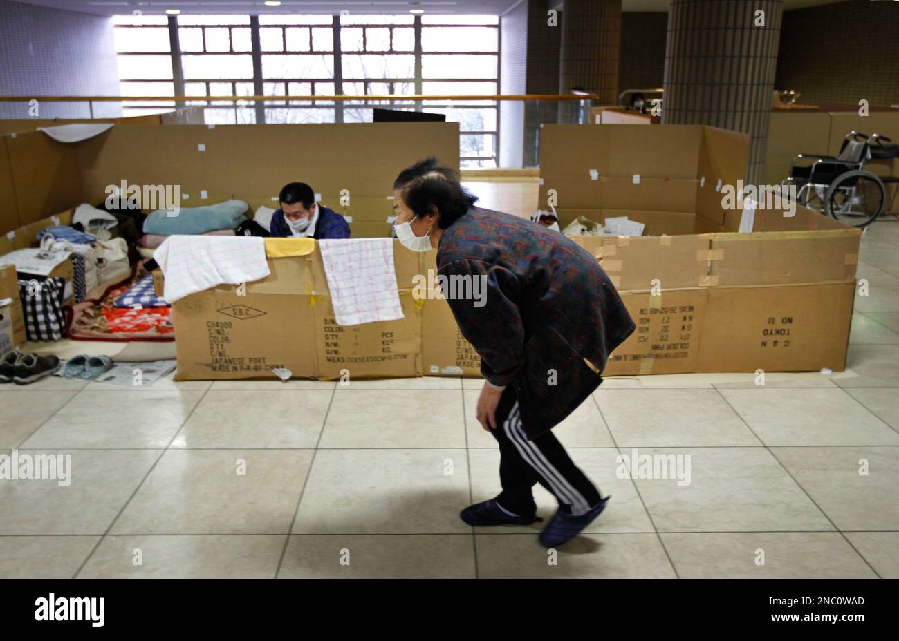 An evacuee walks back to her allotted space at an evacuation center in ...