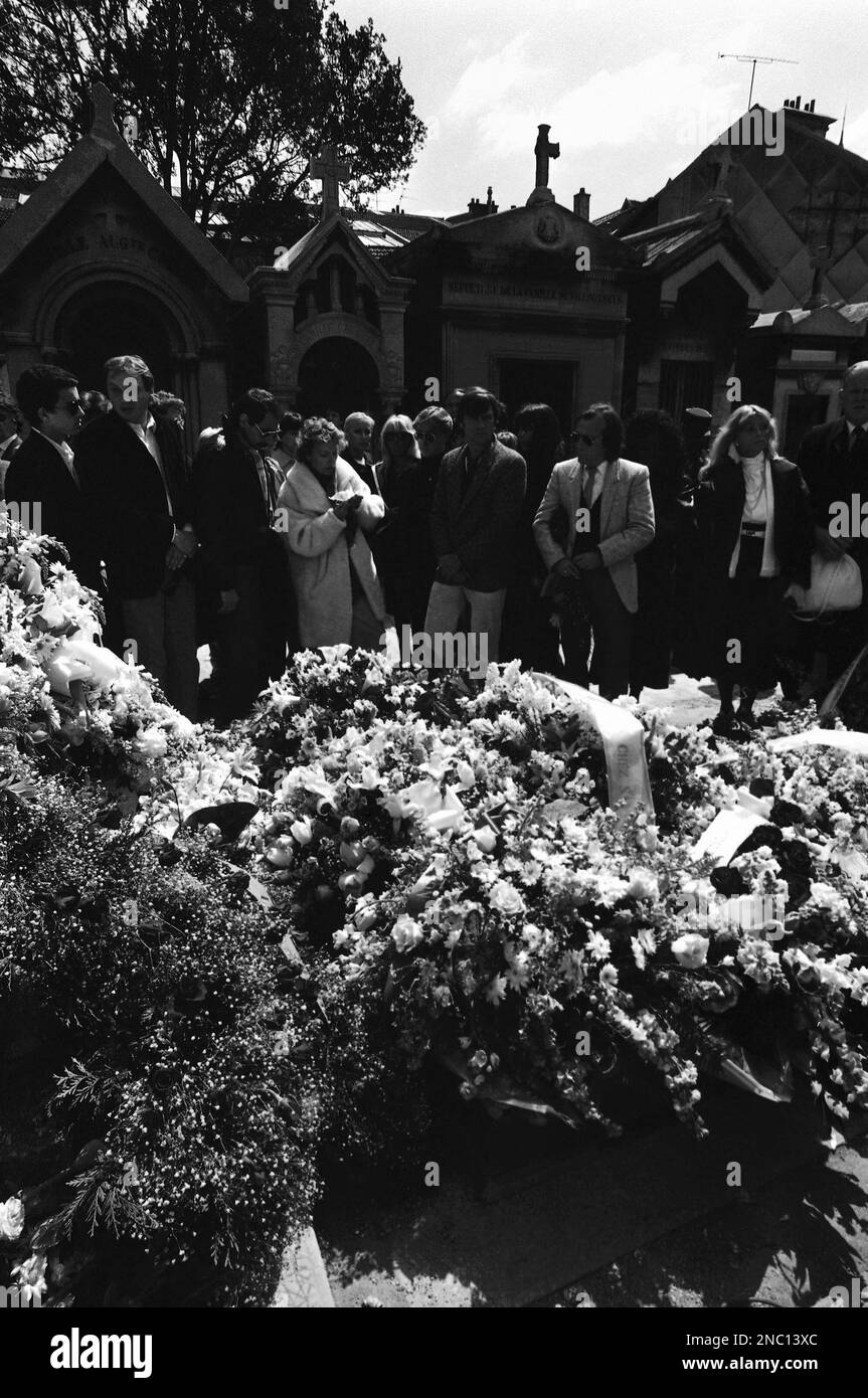 Mourners stand in front of French singer Dalida's grave decorated with ...