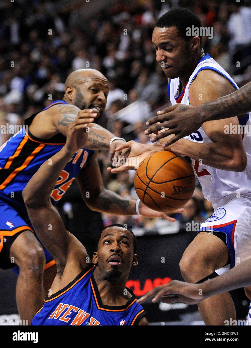 Philadelphia 76ers' Evan Turner (12) grabs a loose ball over New York ...