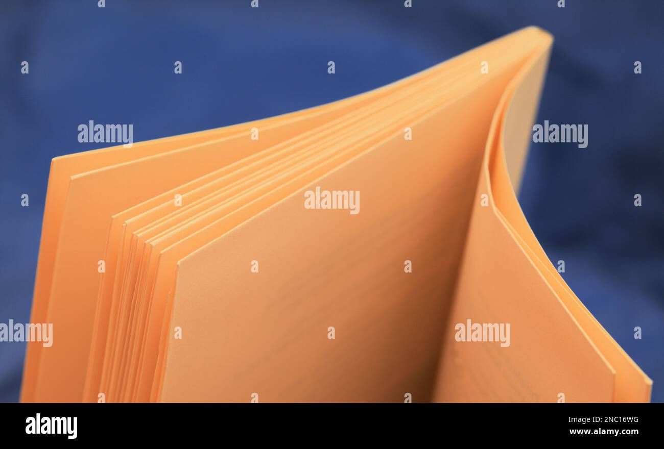 uncut pages of a small new book printed on a yellow vintage style paper ...