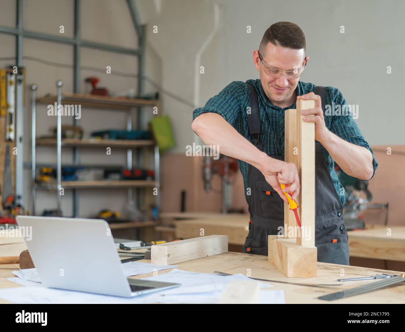 Caucasian man assembling a table with a screwdriver Stock Photo - Alamy