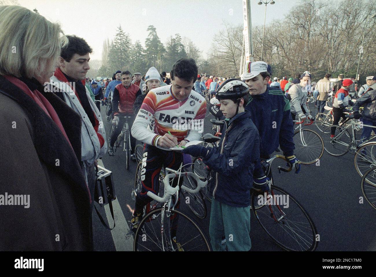 Irish champion cyclist Stephen Roche signs an autograph for a young fan ...