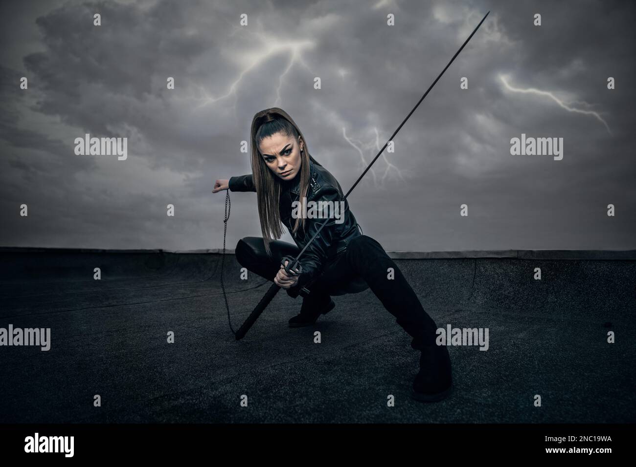 A female in black ninja assassin costume holding a sword, lighting in ...