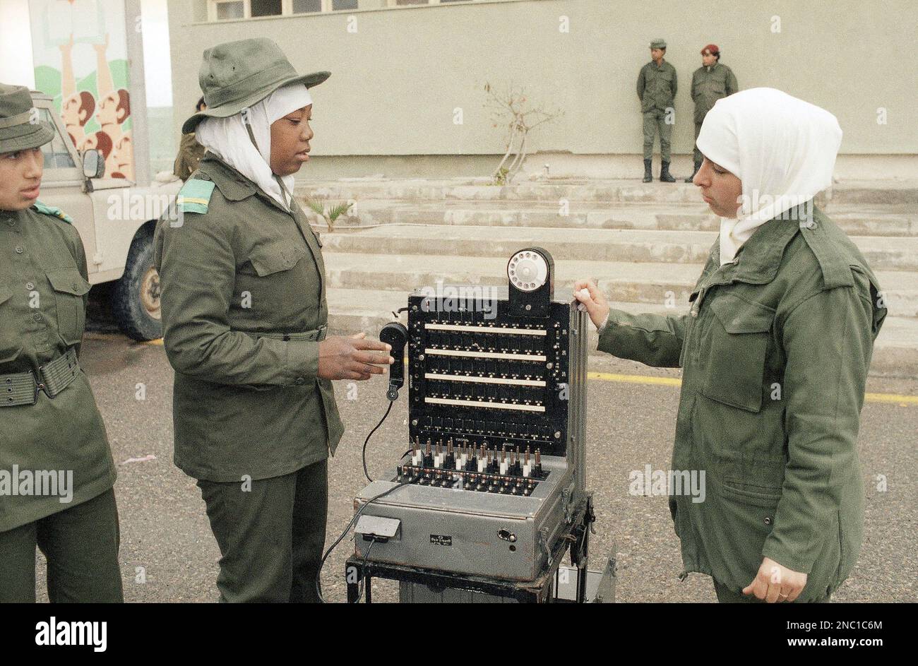 Woman soldiers wear protective overalls and masks during a training ...