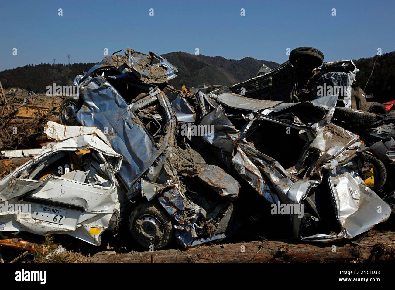 Broken cars are piled near Okawa elementary school in an area ...