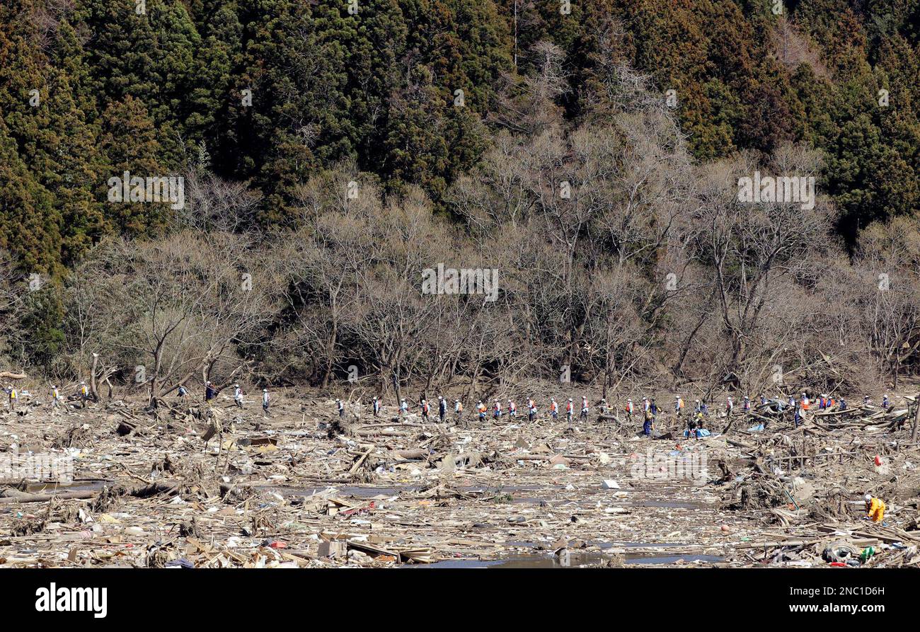 Members of Japanese rescue team march to search victims at a devastated ...