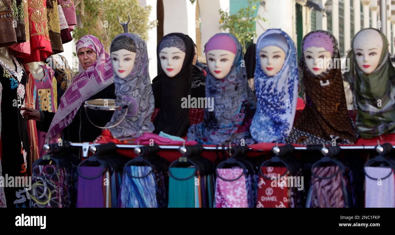 A Libyan woman chooses an outfit near a scarf shop in the Medina, the ...