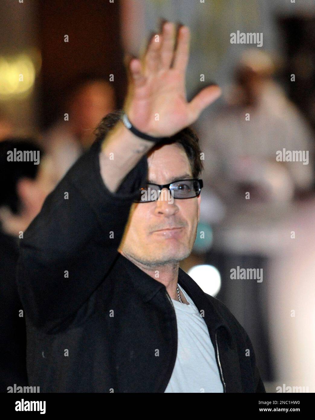 Charlie Sheen waves to fans as he leaves the Chicago Theatre, Sunday ...