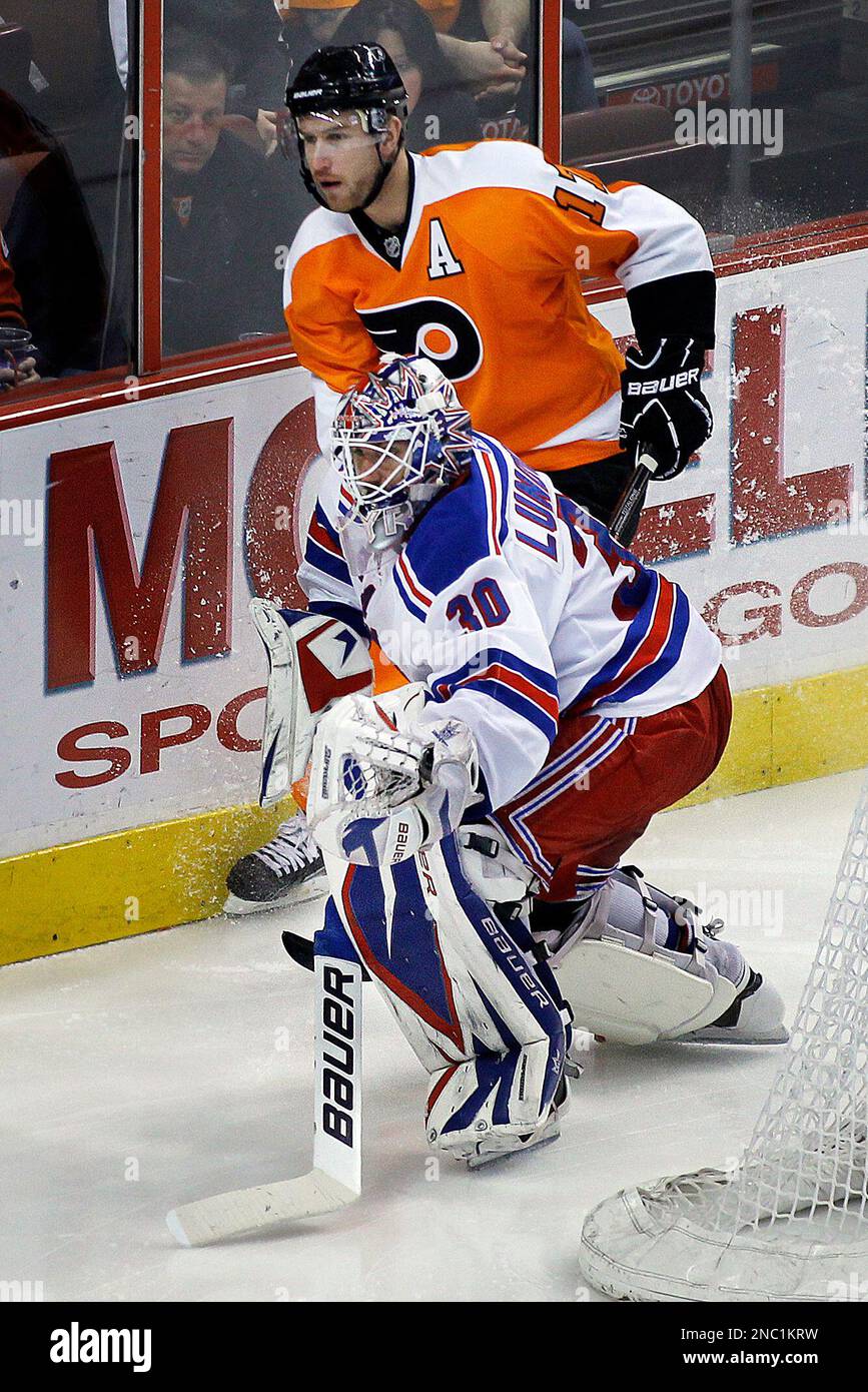 New York Rangers goalie Henrik Lundqvist sweeps the puck away from ...