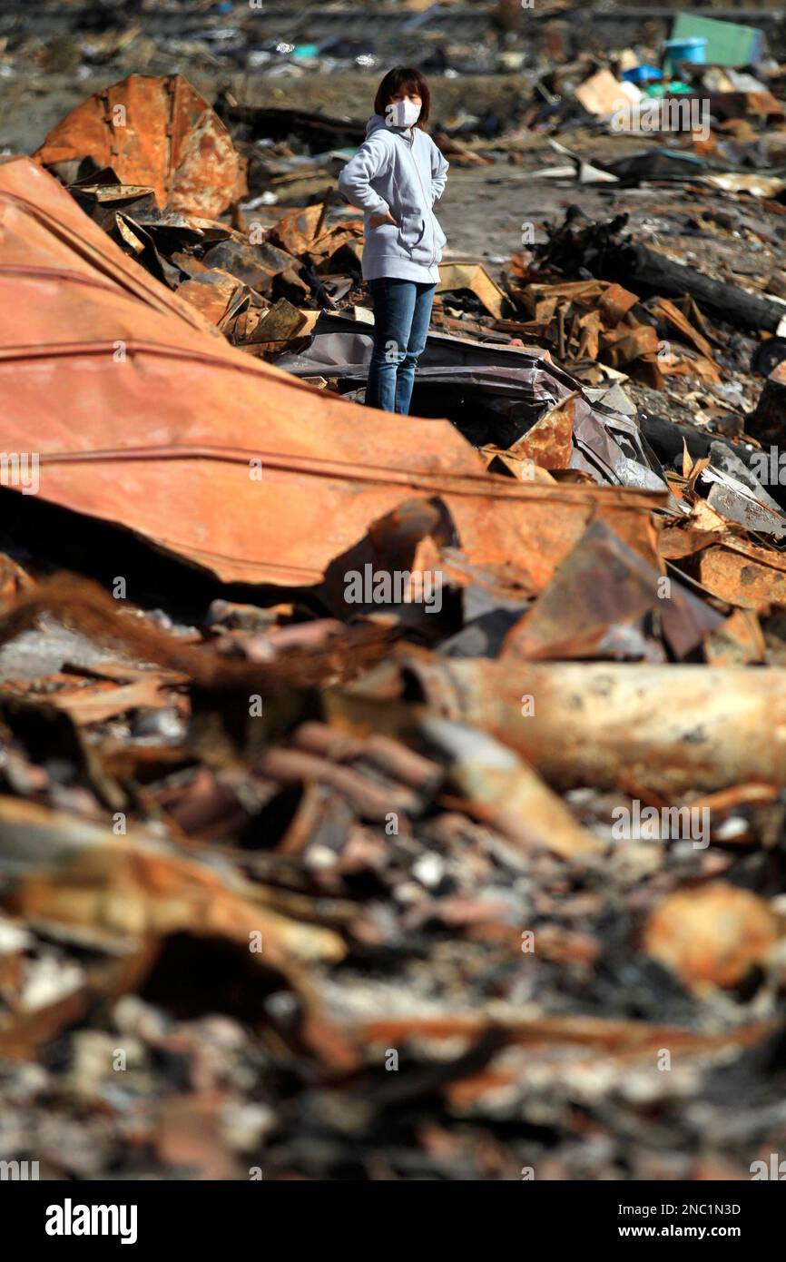 A woman looks over an area devastated by the March 11 tsunami in ...