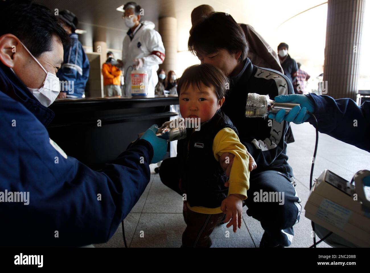 A young boy is screened for radiation contamination before entering an ...