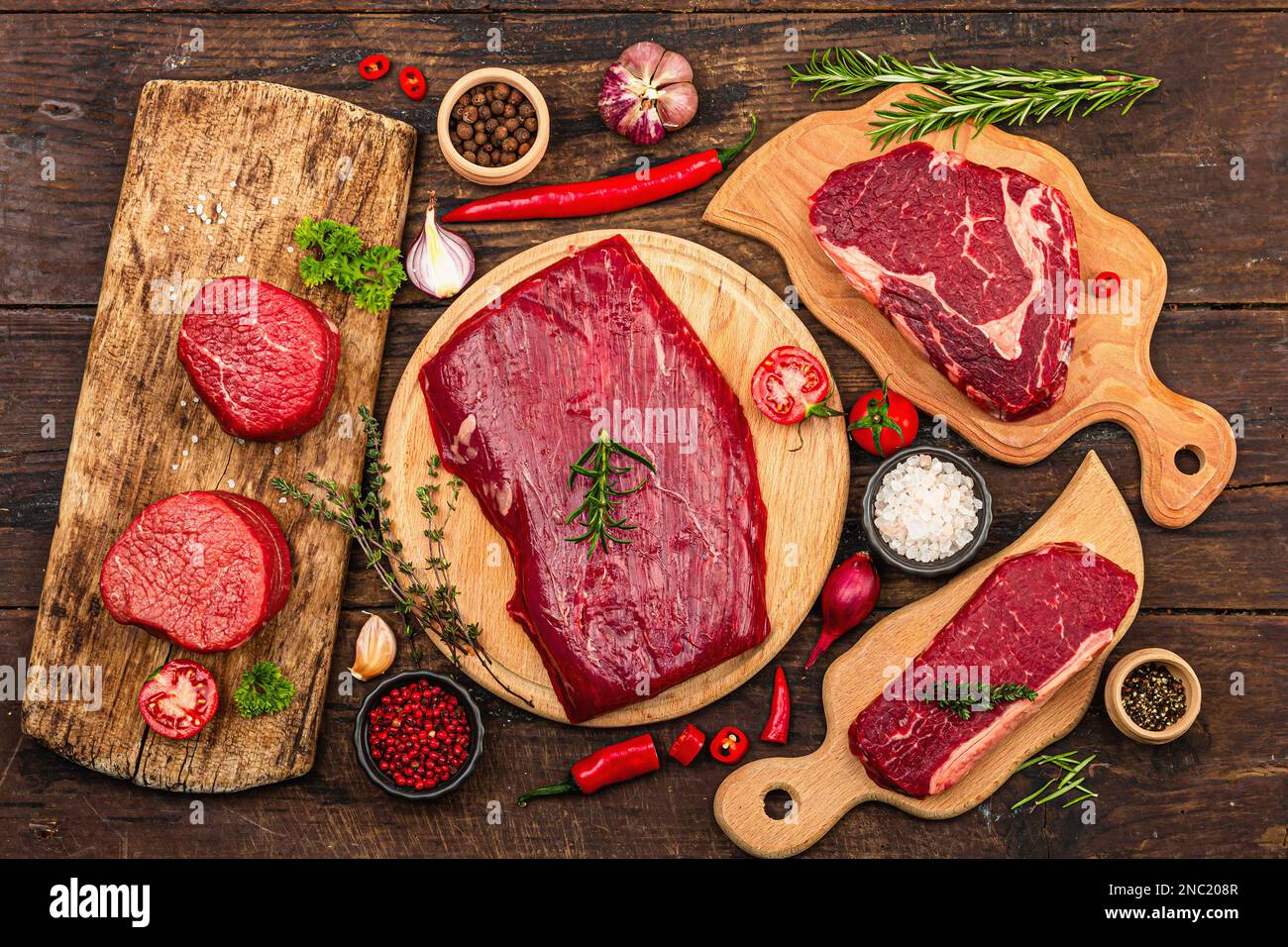Set of various steaks with traditional spices and herbs. Fresh raw meat ...