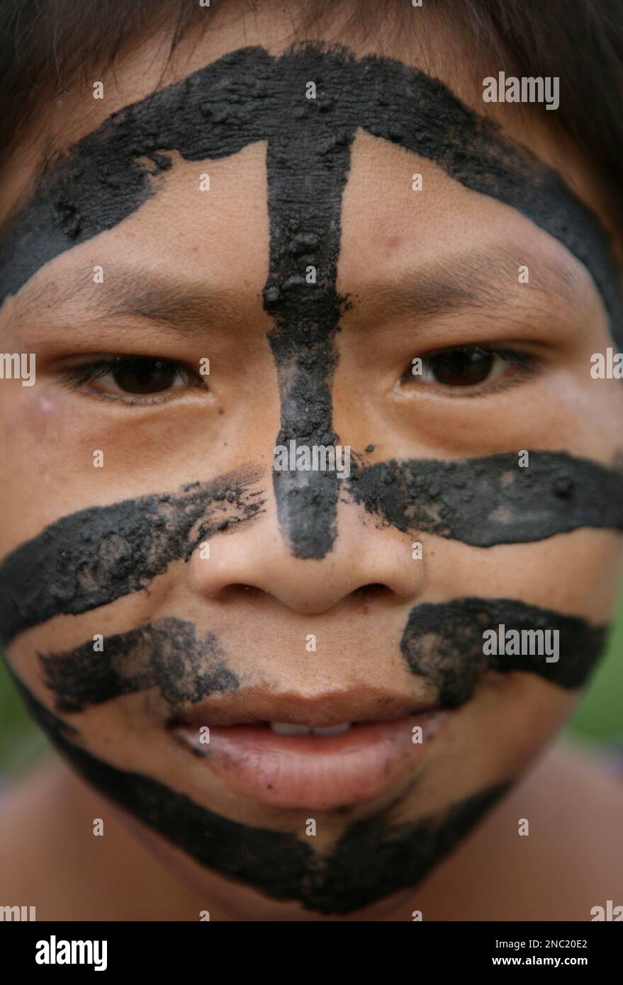 An Ache indigenous youth with his face marked with traditional painting ...