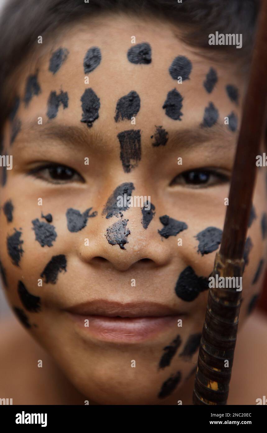 An Ache indigenous youth with his face marked with traditional painting ...