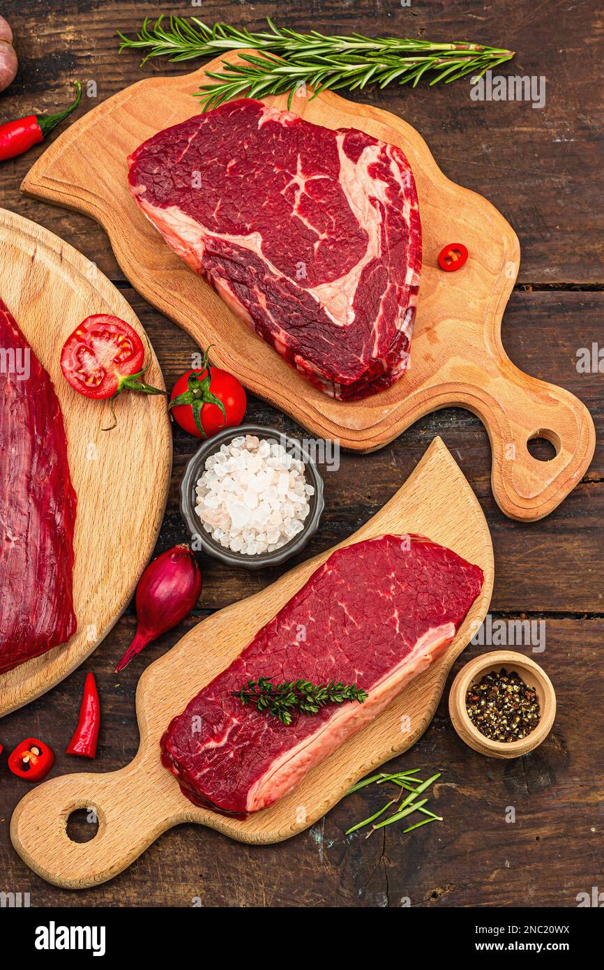 Set of various steaks with traditional spices and herbs. Fresh raw meat ...