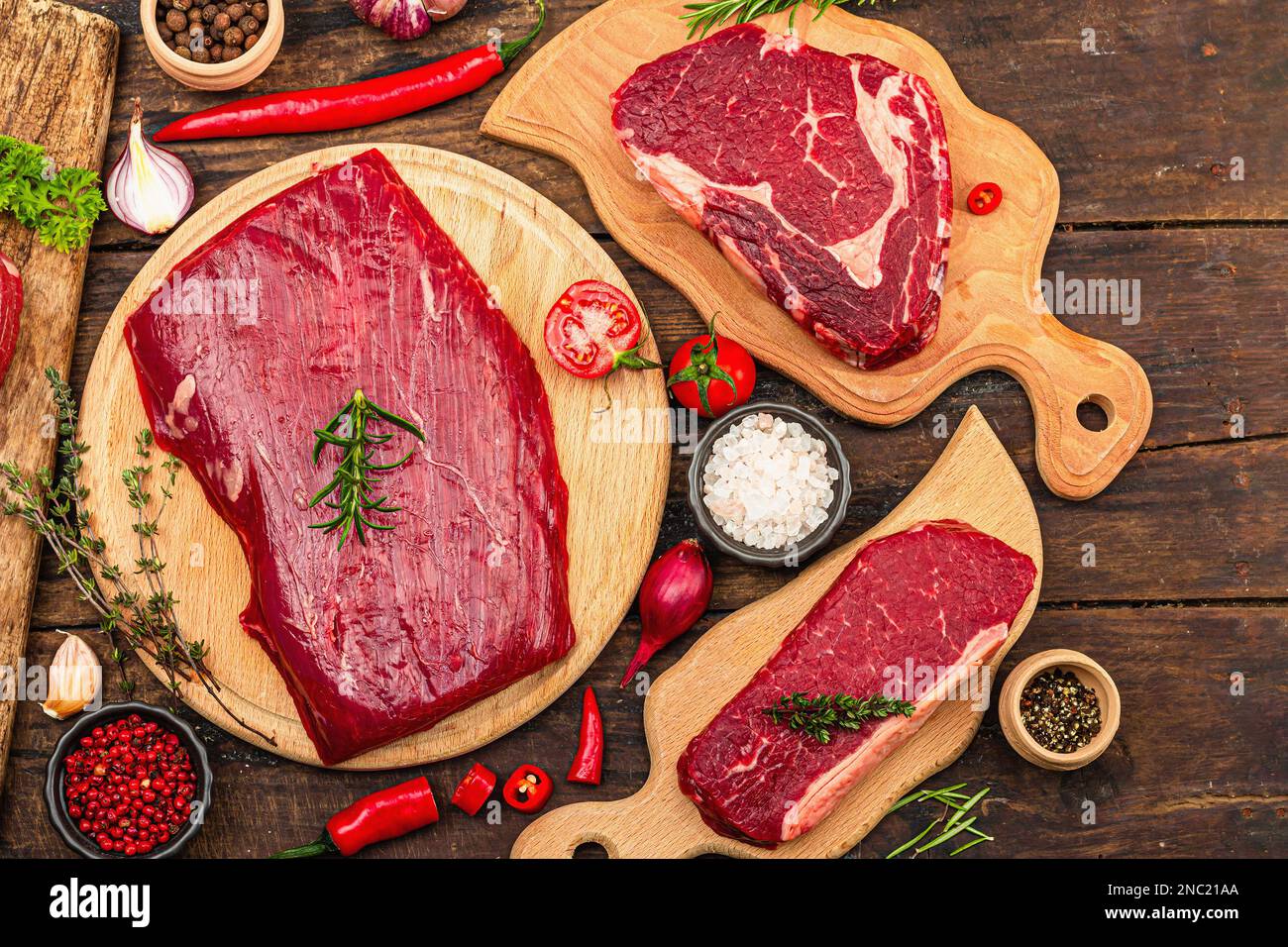 Set of various steaks with traditional spices and herbs. Fresh raw meat ...