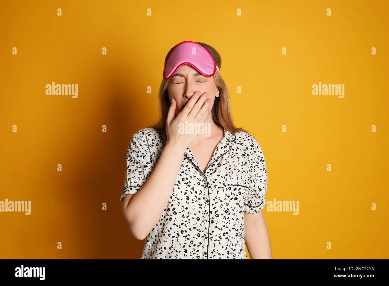 Young tired woman with sleeping mask yawning on yellow background Stock ...